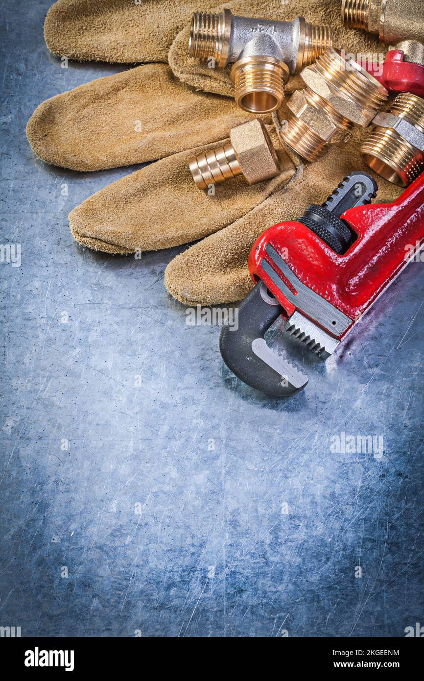 Monkey wrench protective gloves brass pipe connectors on metallic ...