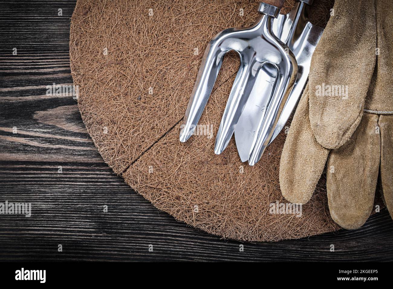 Mulching circle shovel trowel fork leather protective gloves on wooden ...