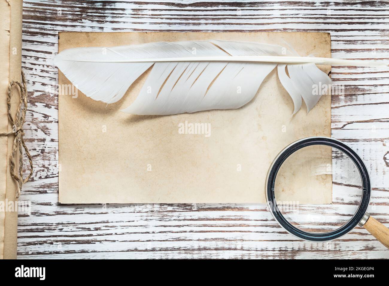 Old sheet corded paper roll feather magnifier on vintage wooden board ...