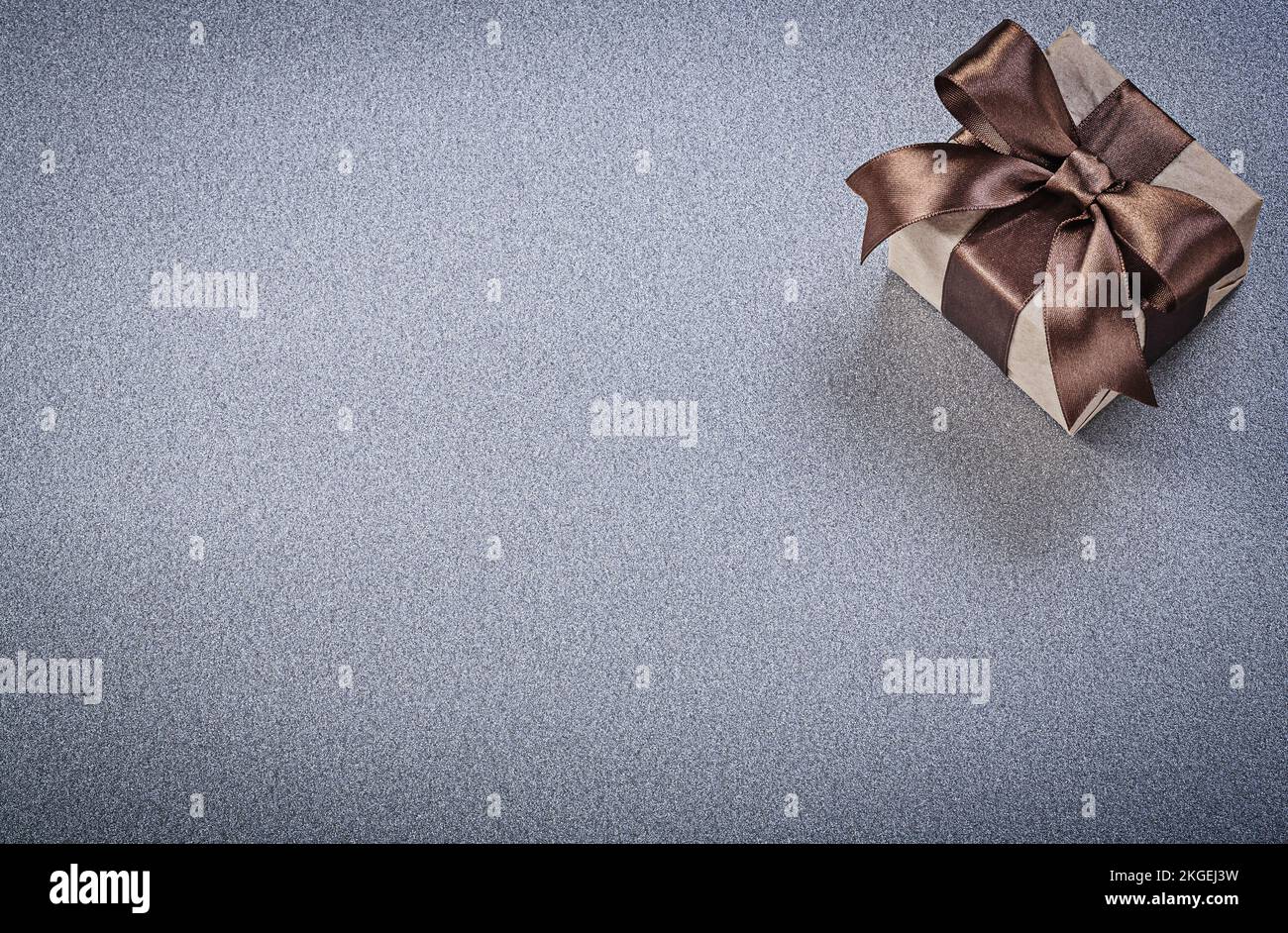 Packed present box in brown paper on grey background copy space ...