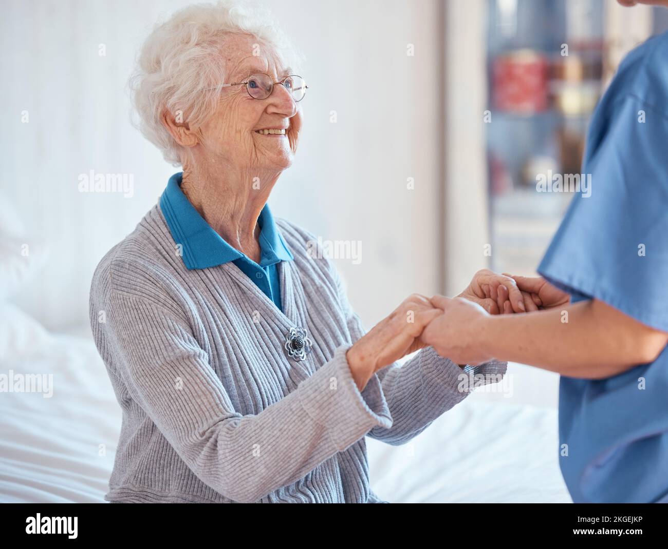 Elderly woman, nurse holding hands and nursing home support with medical professional exam ...