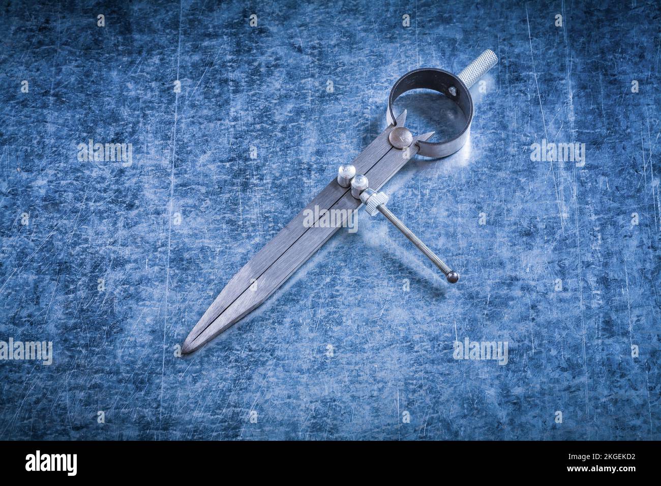 Pair of construction compasses on scratched metallic background Stock ...