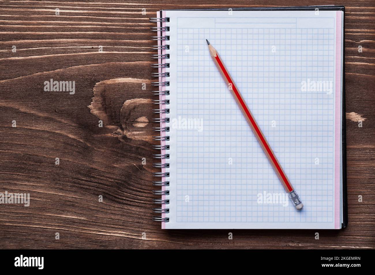 Pencil and squared notepad on pine brown wooden board office concept ...