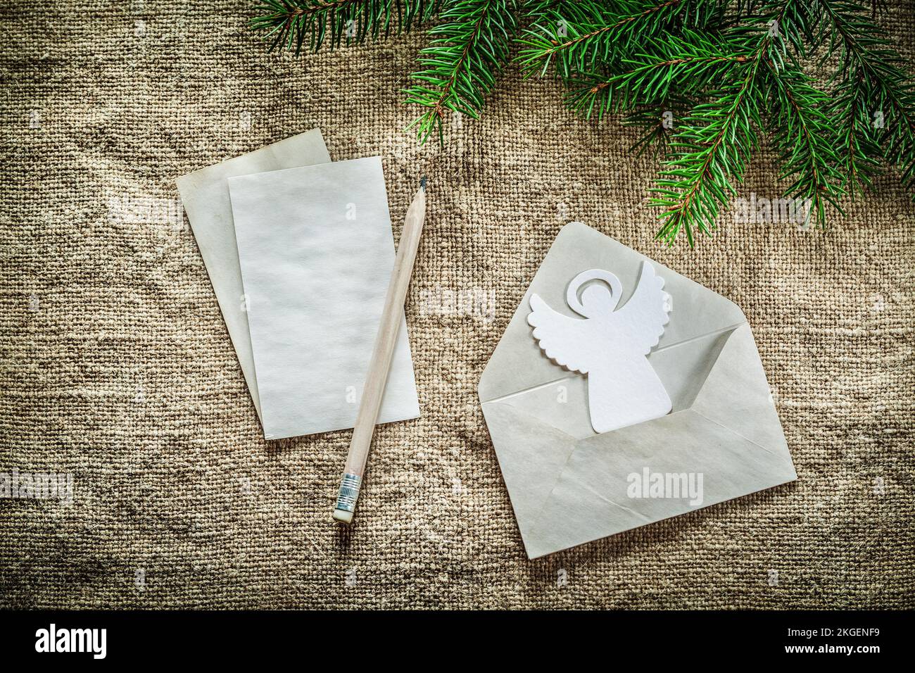 Pine tree branch envelope letter pencil angel on sacking background ...