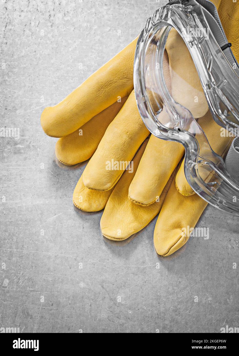 Plastic goggles protective gloves on scratched metallic background ...