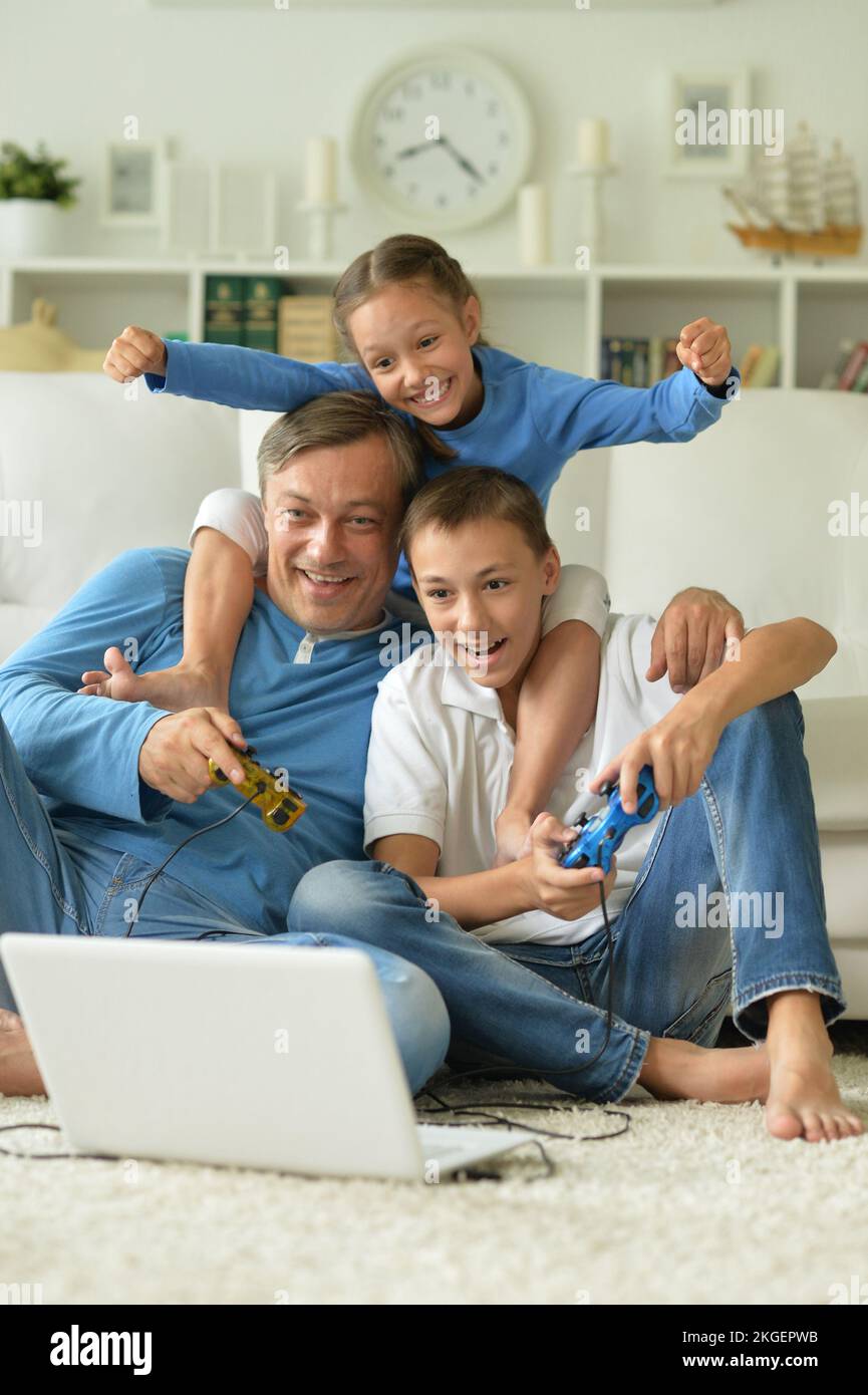 dad and kids have fun playing with a laptop Stock Photo - Alamy