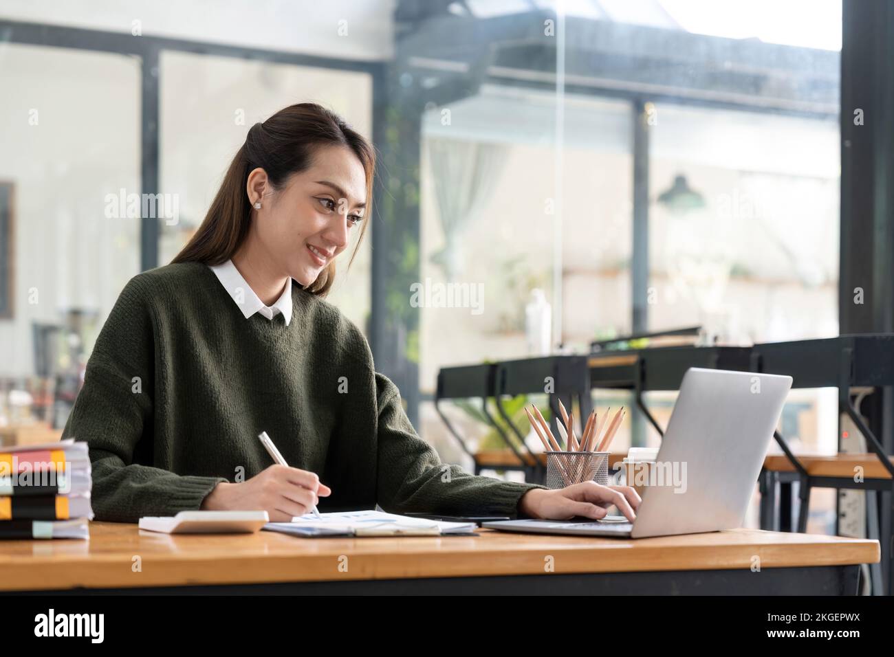 Portrait young asian studying remotely from home, using a laptop ...