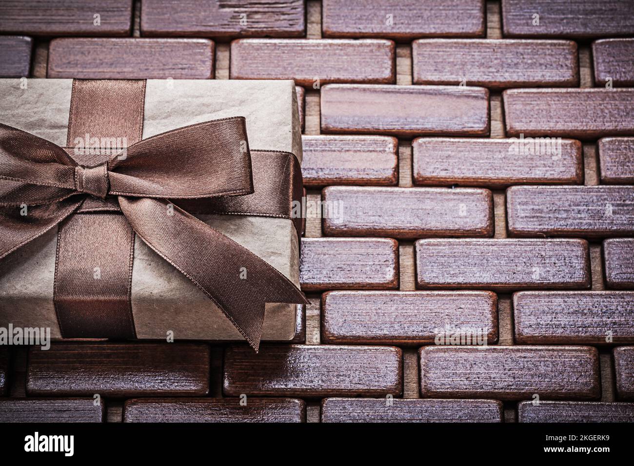 Present with tied ribbon on wooden mat holidays concept Stock Photo - Alamy