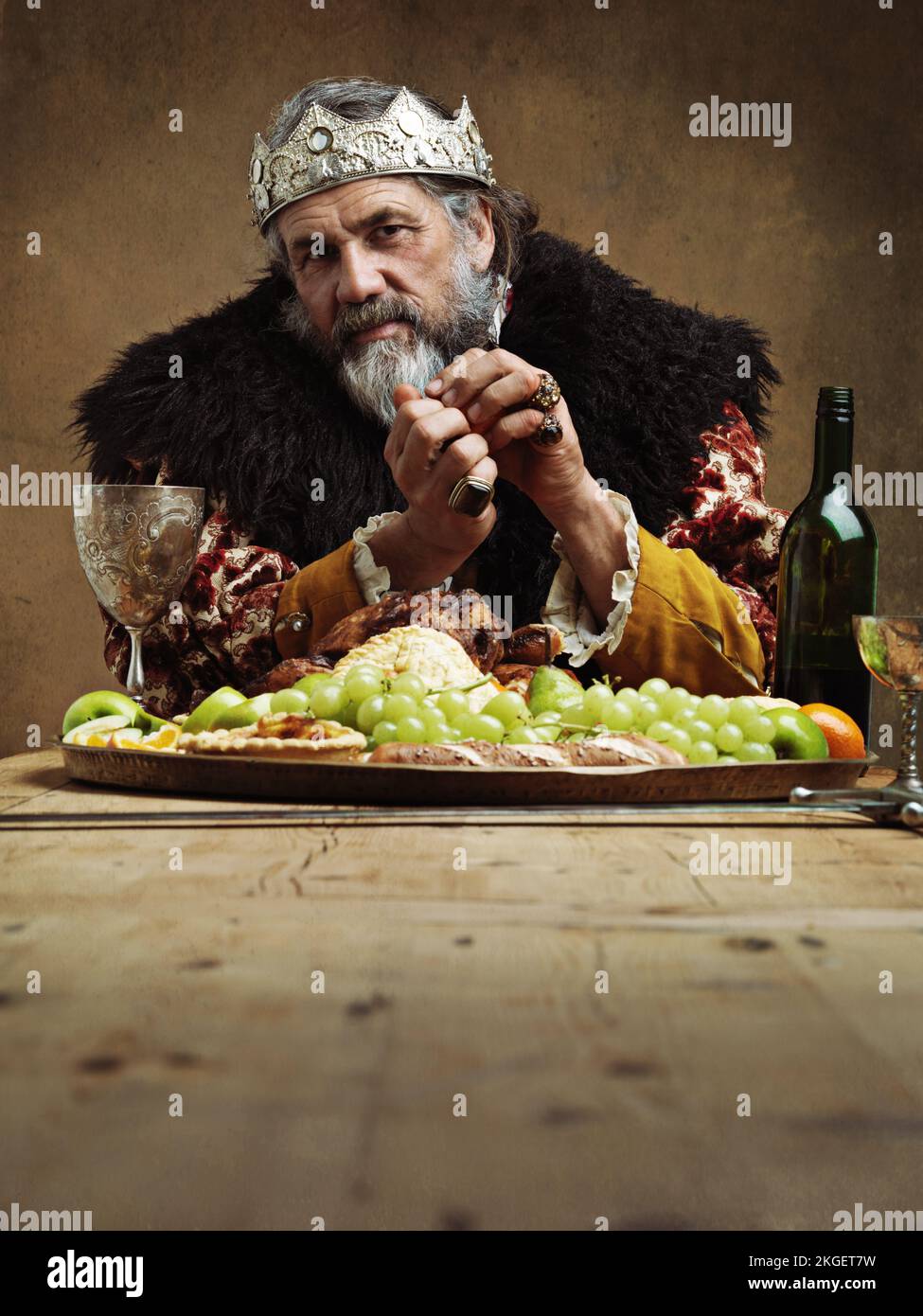 Being King has its perks. A mature king feasting alone in a banquet ...