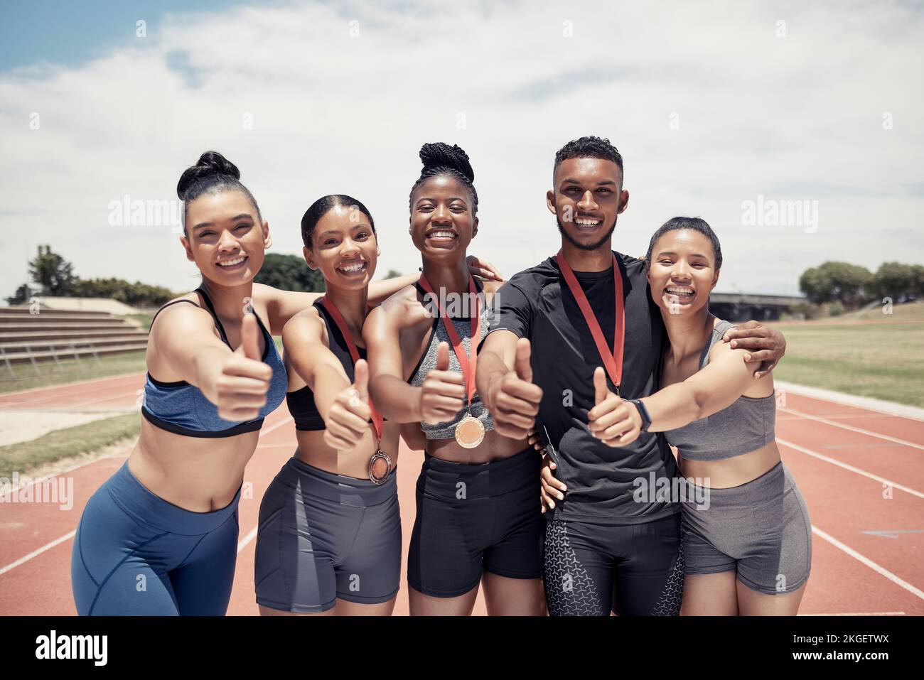 Team, thumbs up and sport winner with medal, runner and happy in ...