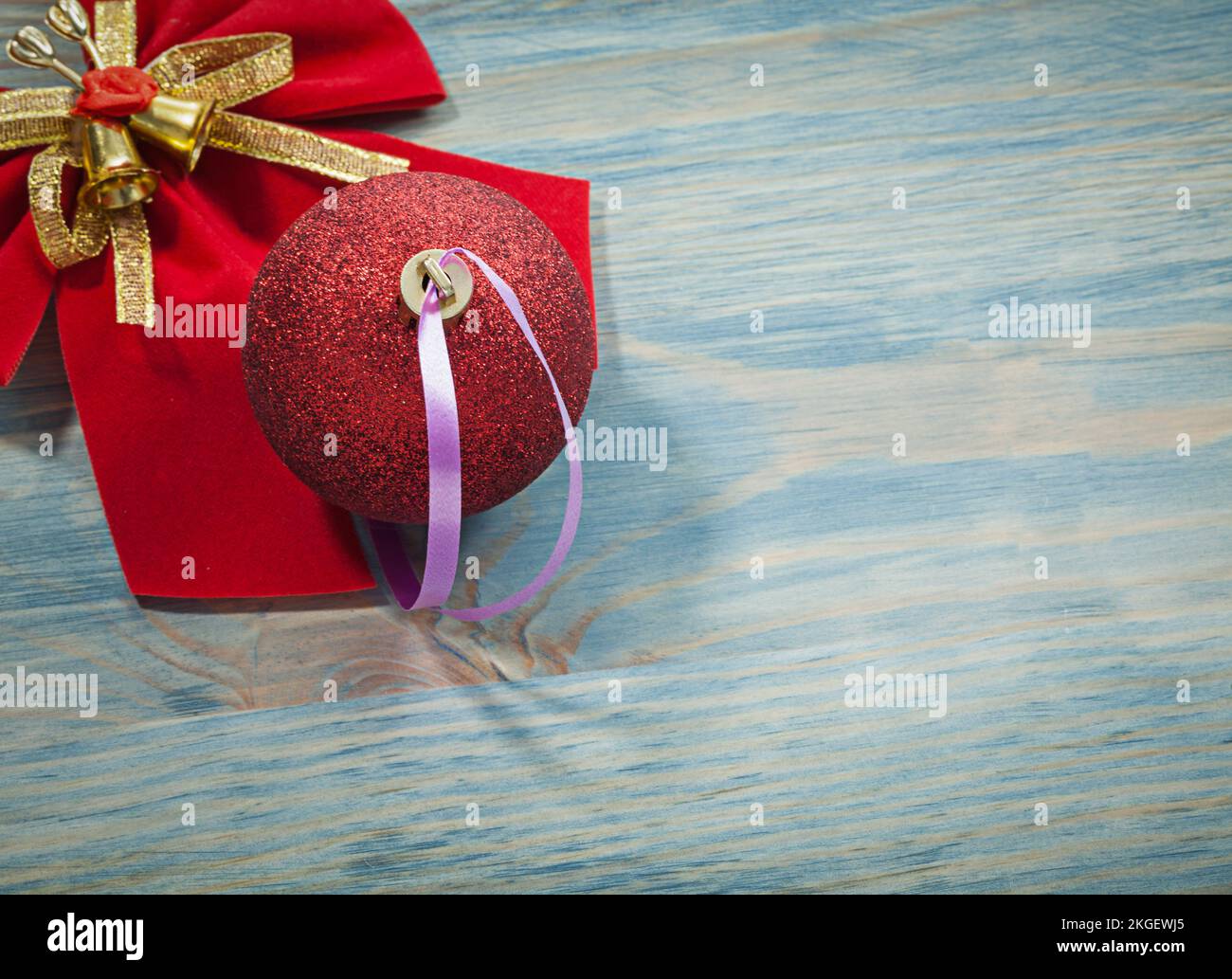 Red Christmas ball bow with bell on wooden board holidays concept Stock ...
