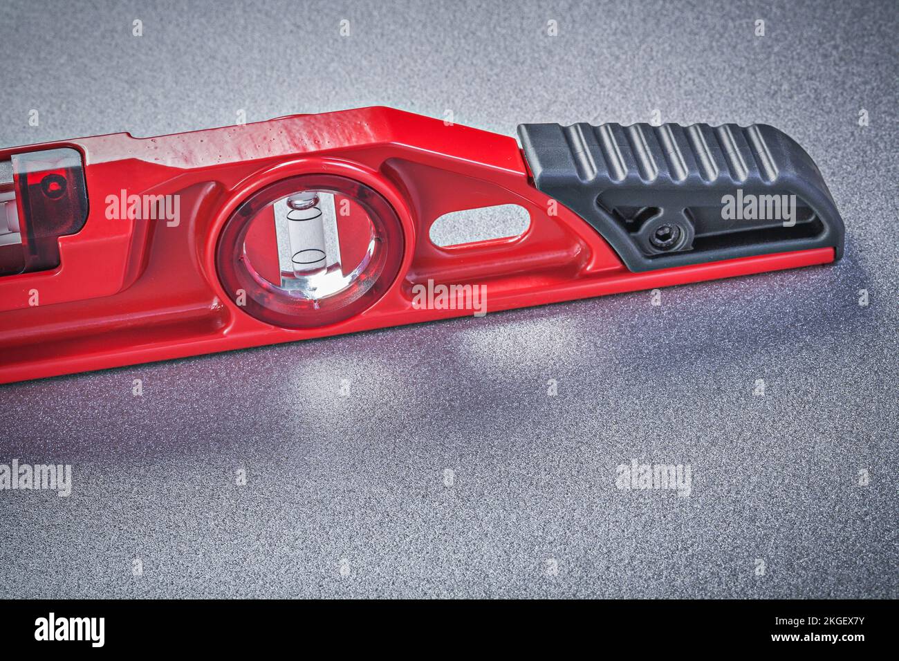 Red construction level on grey background front view maintenance ...