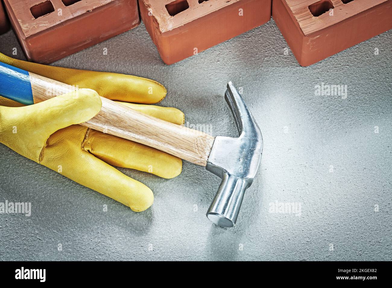 Red construction bricks safety gloves claw hammer on concrete ...