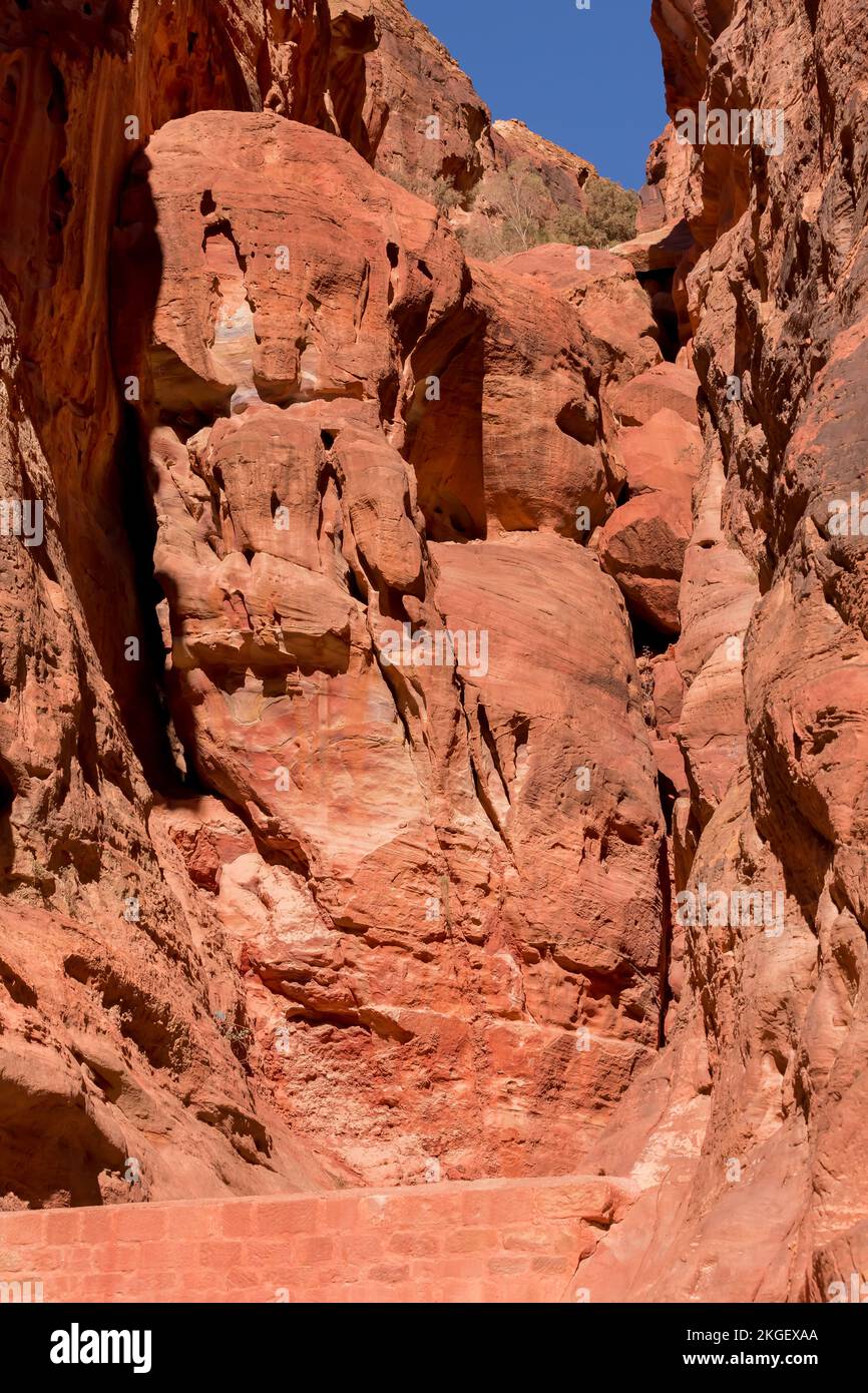 The Siq, narrow red canyon, rocks background in Petra, Jordan, UNESCO ...