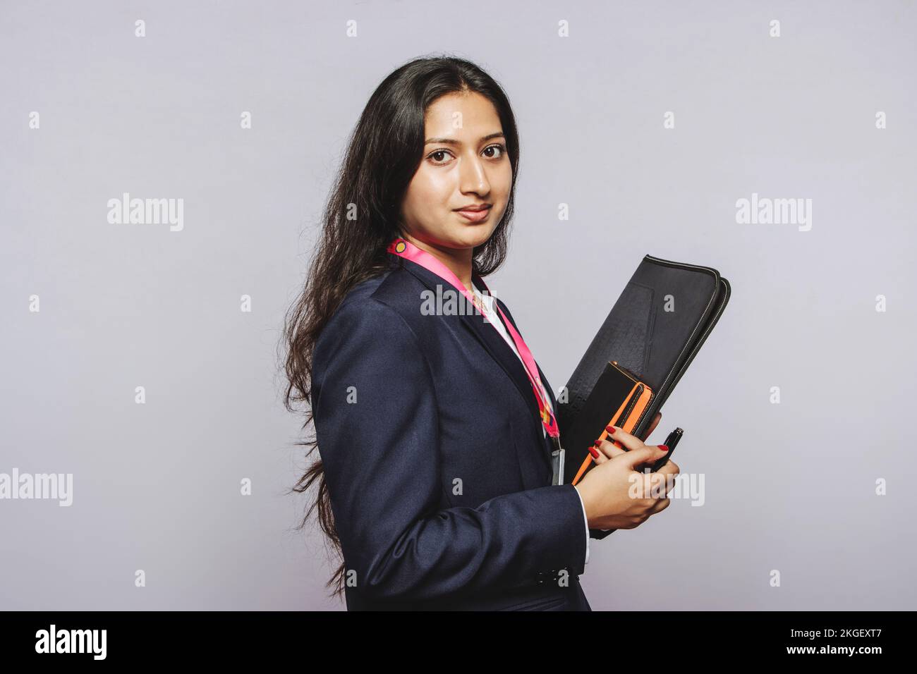 Happy pretty female school coaching teacher student in a blue blazer holding a books folder ...