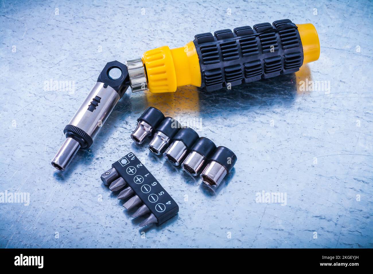 Reversible screwdriver screw bits and torxes on metallic background ...