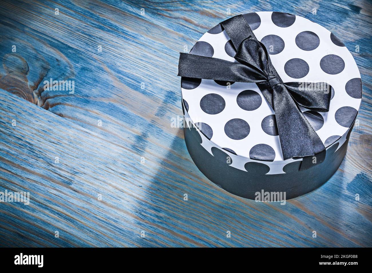 Round present box with blue ribbon on wooden board holidays concept ...
