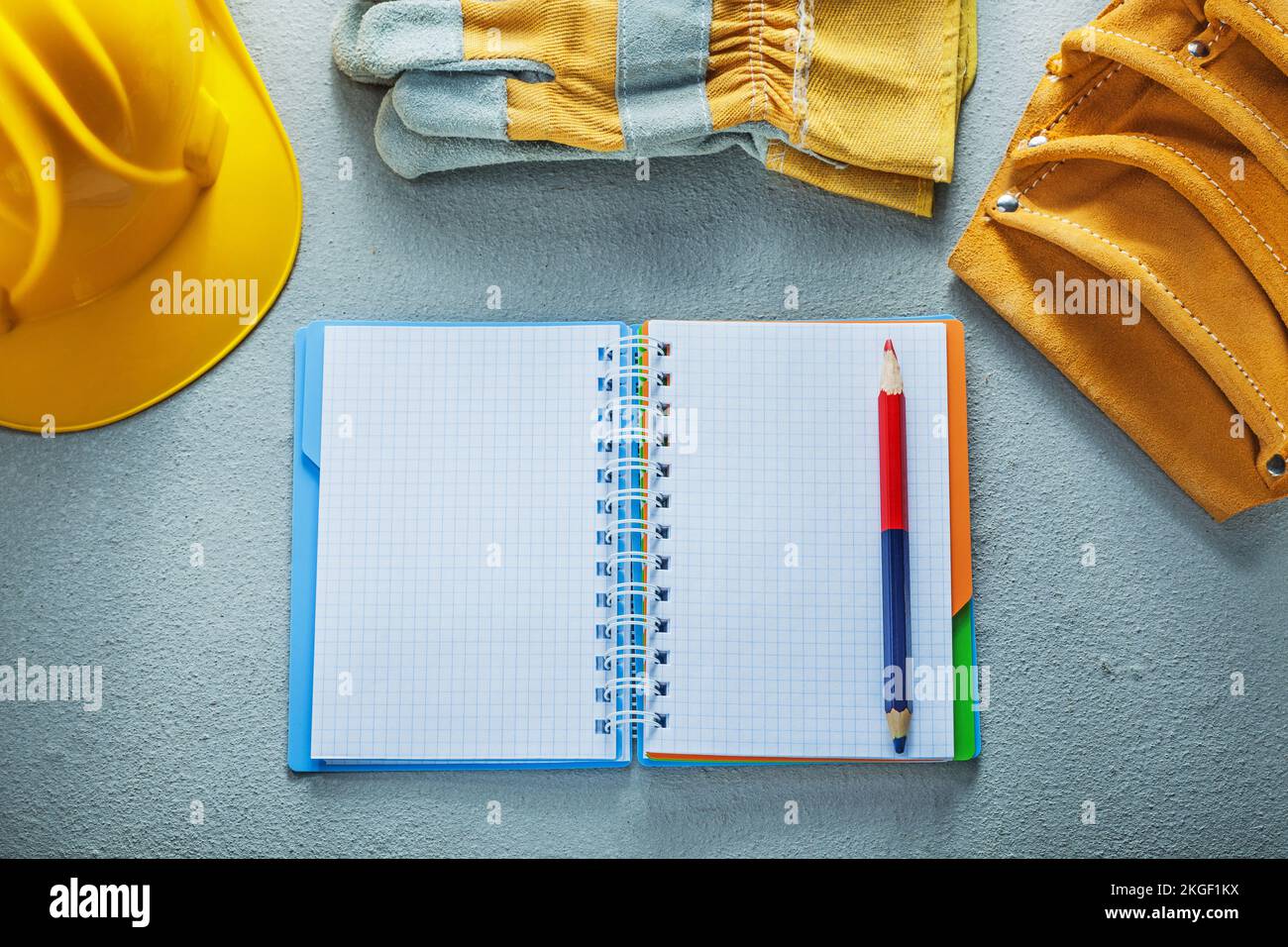 Safety gloves hard hat notepad pencil tool belt on concrete background ...