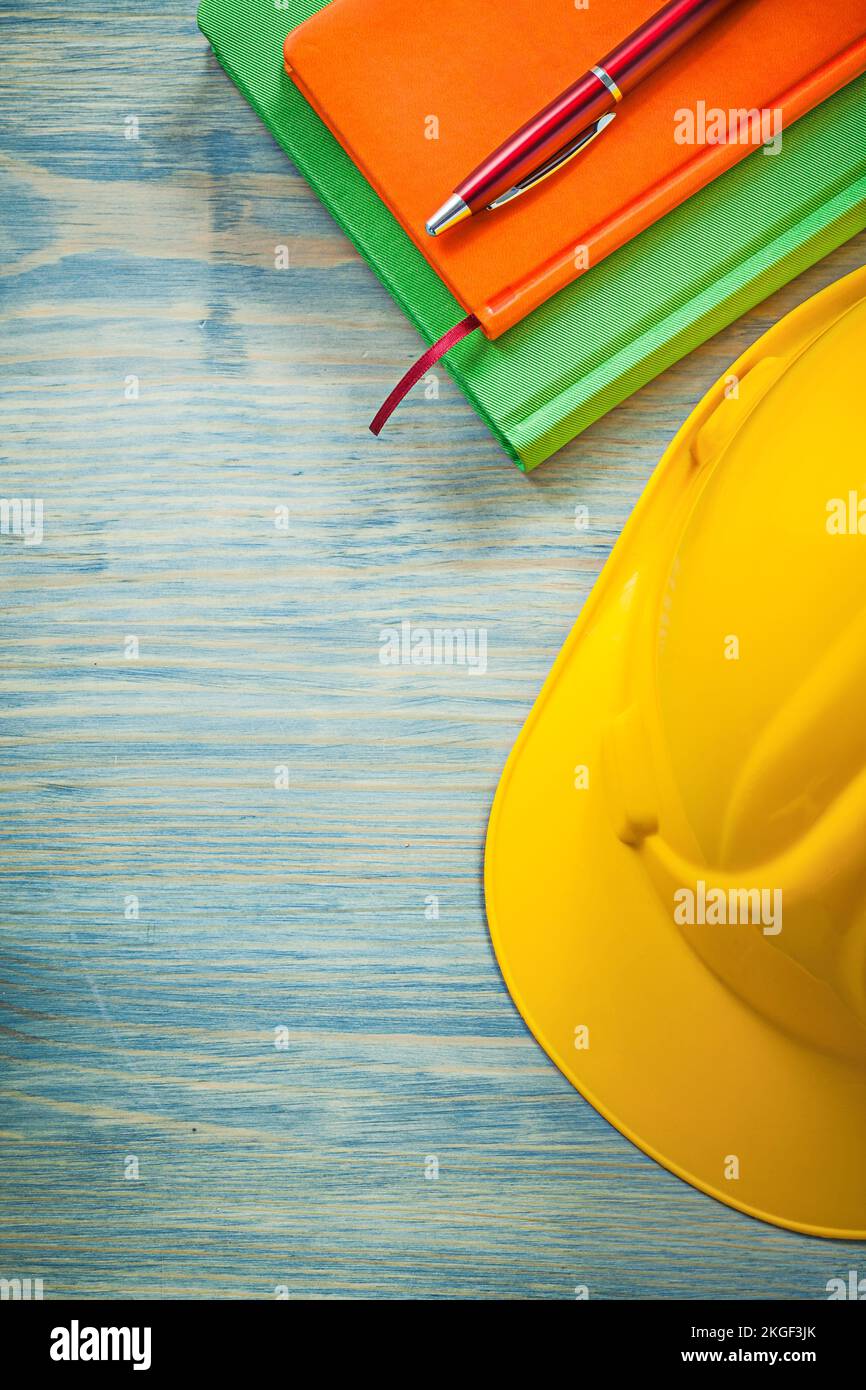 Set of building helmet notepads ballpoint pen on wood board ...