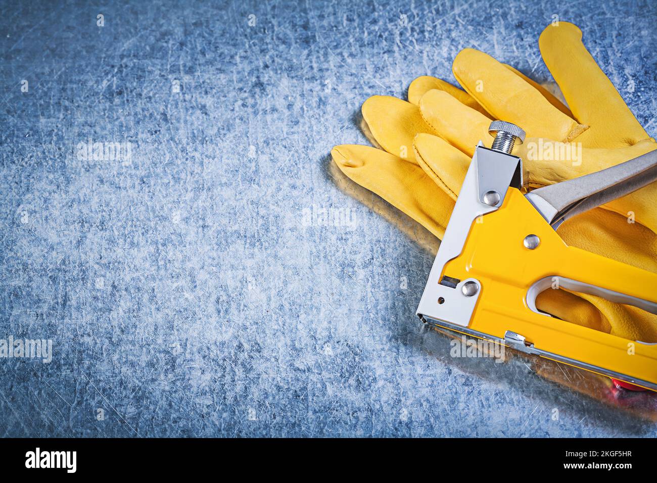 Set of safety gloves stapler gun on metallic background construction ...