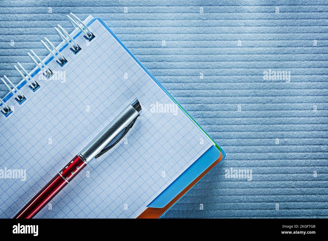 Spiral checked notepad biro pen Stock Photo - Alamy