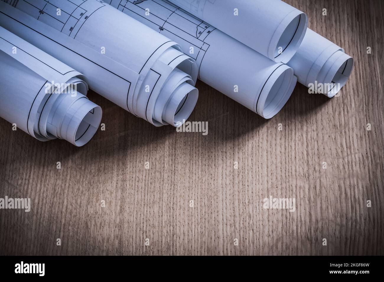 Stack of rolled construction plans on wooden background Stock Photo - Alamy