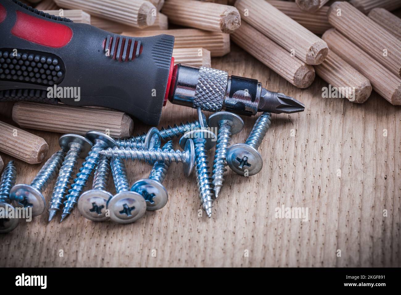 Stack of wooden dowel pins steel nails and insulated turnscrew Stock ...