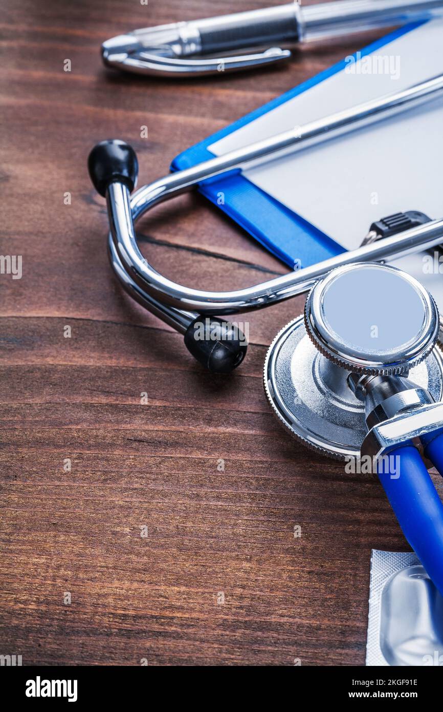 stethoscope clipboard ballpoint pen on vintage wooden board wery close ...