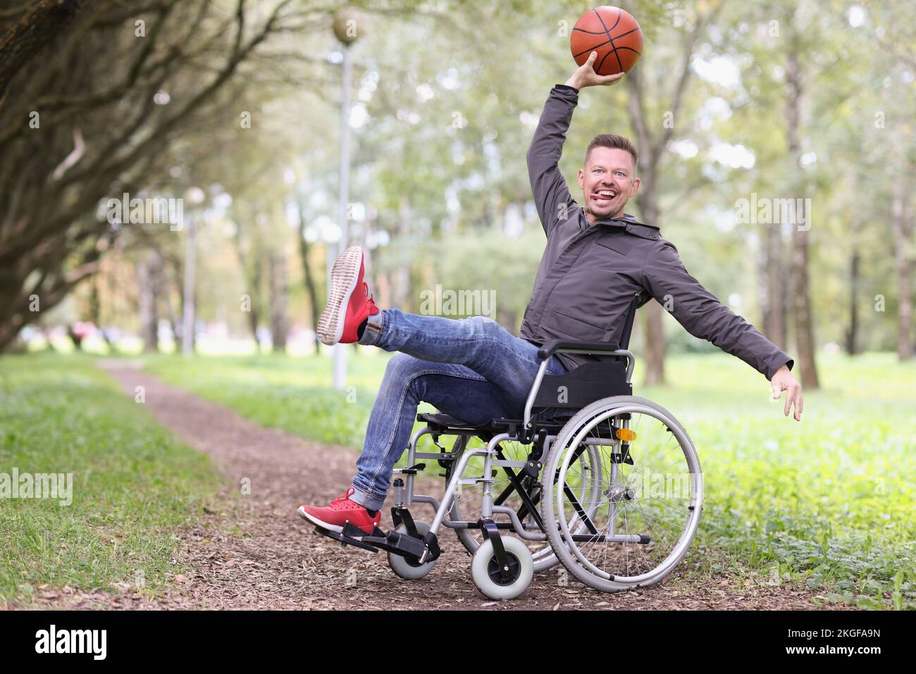 Funny smiling disabled man playing with basketball ball Stock Photo - Alamy