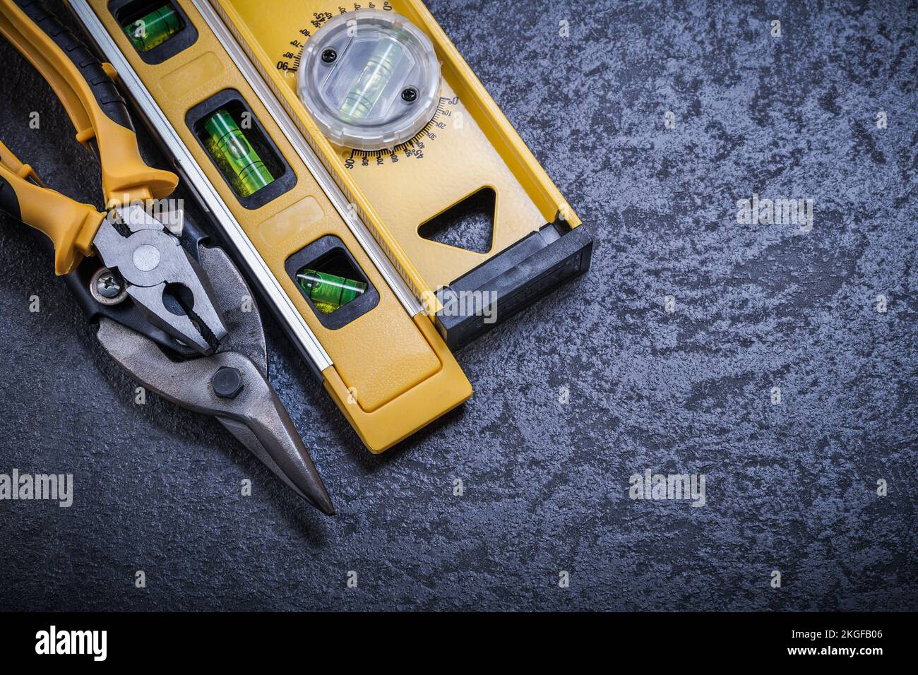 Tin snips construction level on black background Stock Photo - Alamy