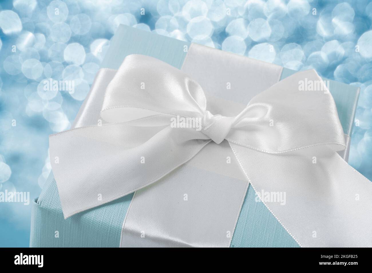 top view blue gift box with white bow on blurred background Stock Photo ...