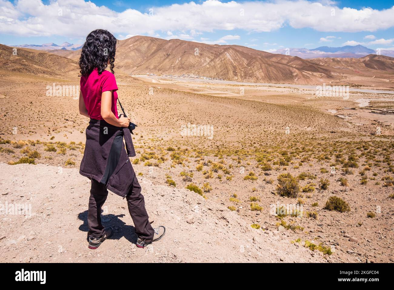 Female tourist looking at the village of San Pablo de Lipez seen from ...