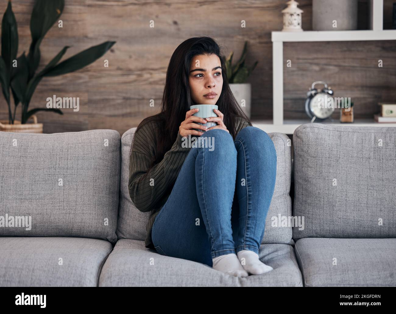 Lonely girl sitting on sofa hi-res stock photography and images - Alamy