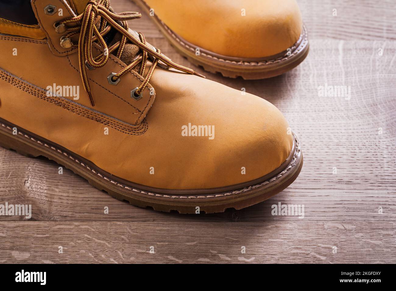 very close up view on pair of working boots wood board Stock Photo - Alamy