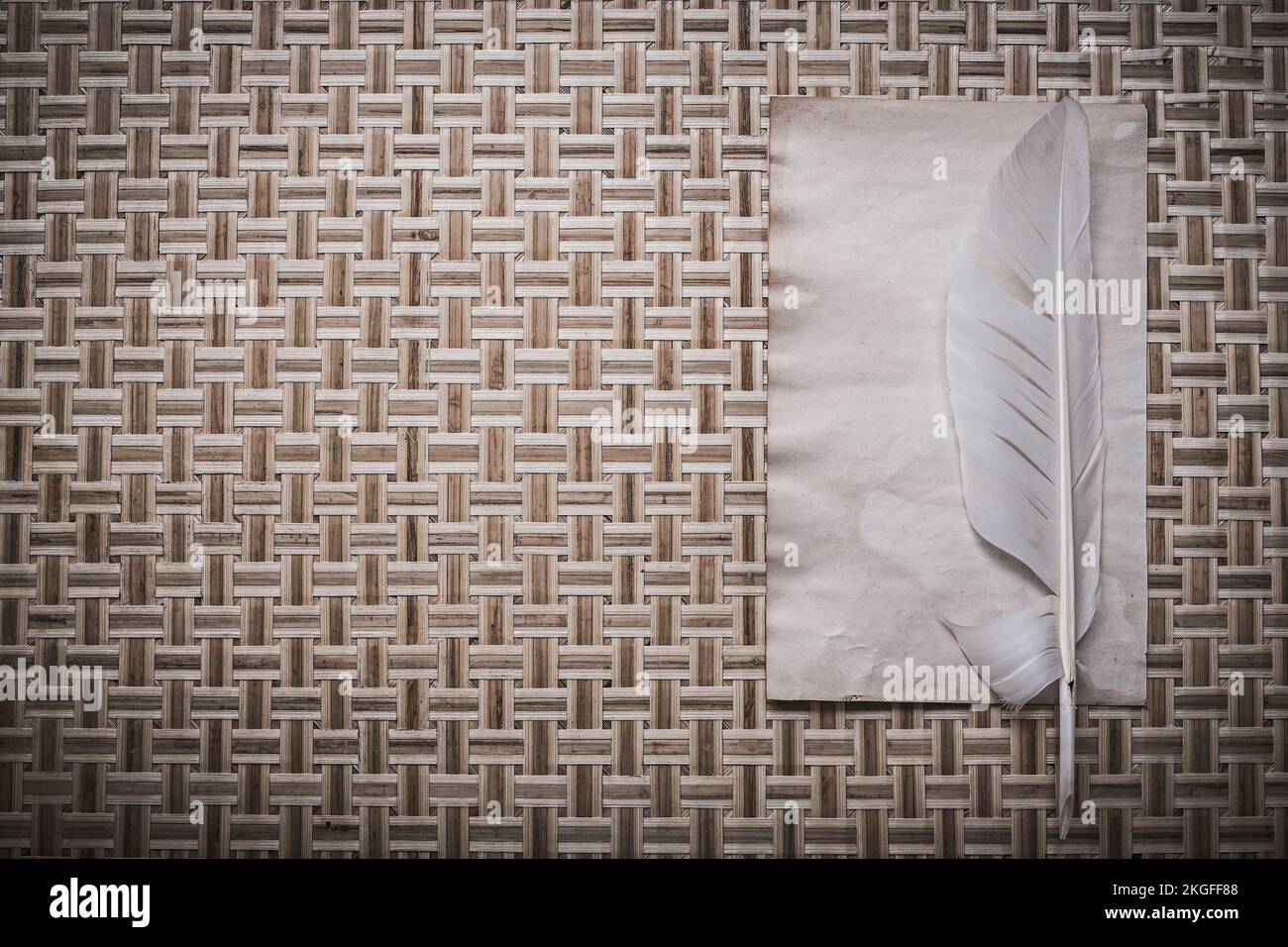 Vintage clean sheet of paper feather on wicker wooden matting Stock ...