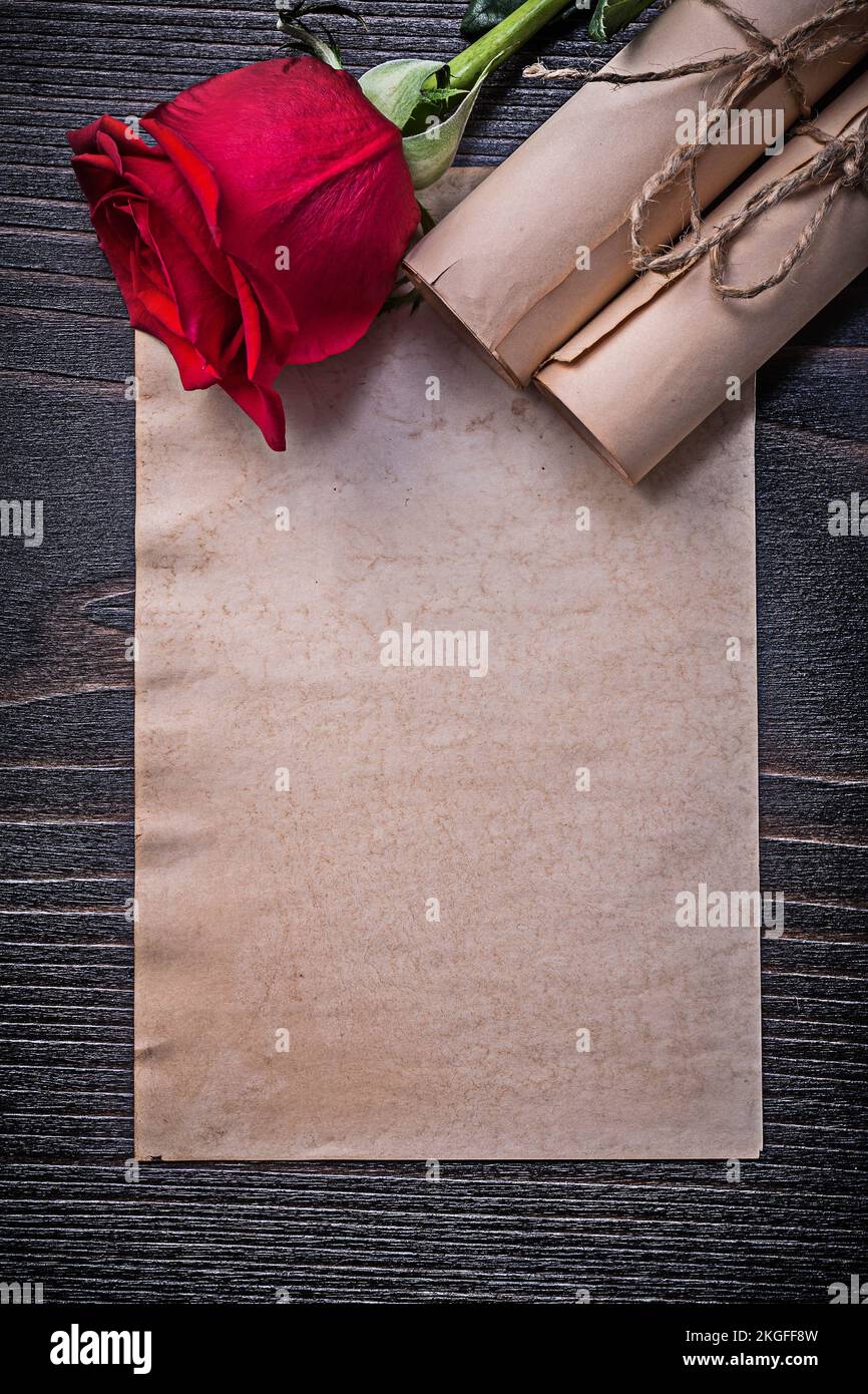 Vintage corded paper rolls red expanded rose on wooden board Stock ...