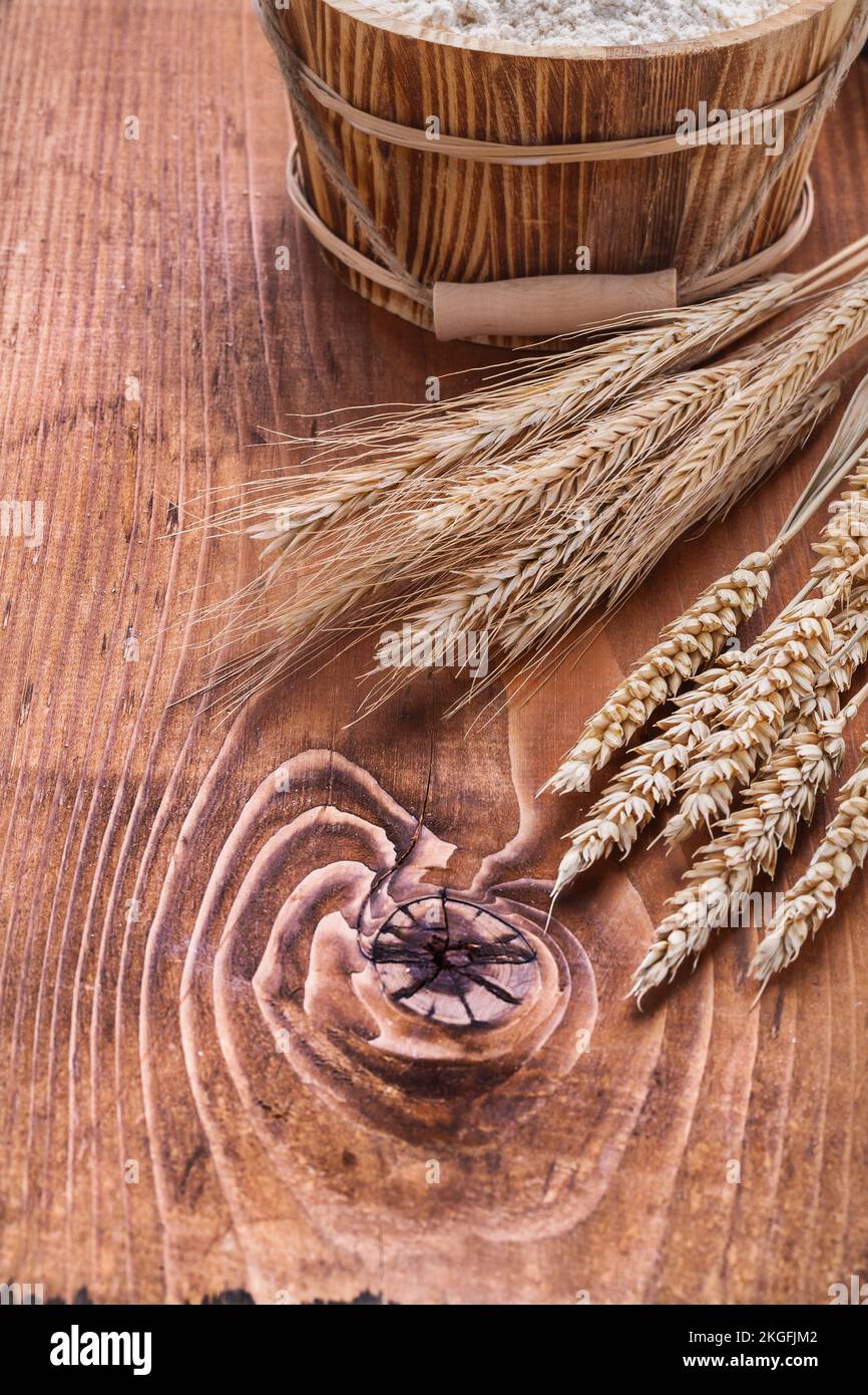 wheat ears with bucket of flour on old wooden board Stock Photo - Alamy