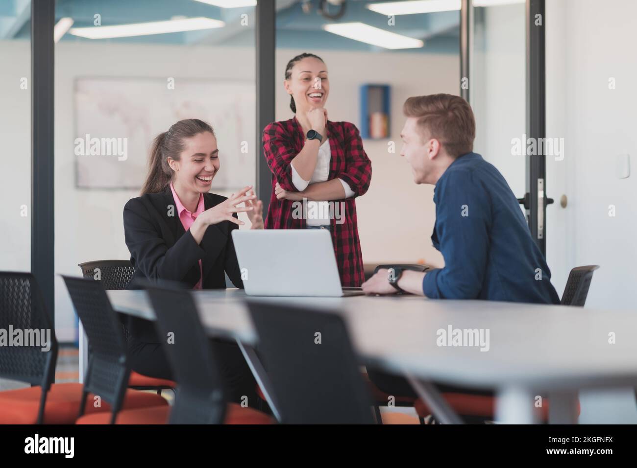Successful young female leader in a suit with a pink shirt sitting in a ...