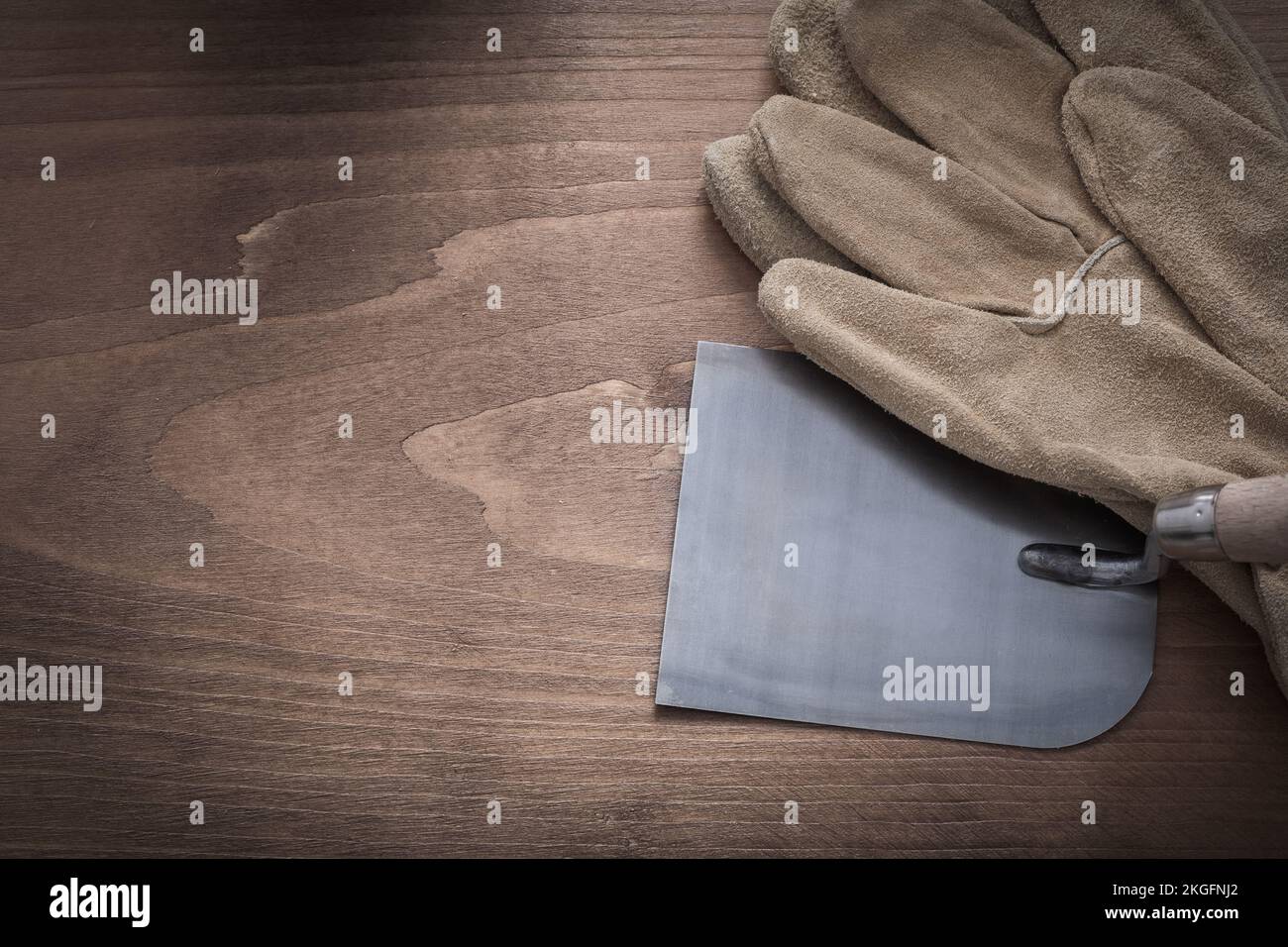 Working protective gloves and plastering trowel on vintage wooden ...