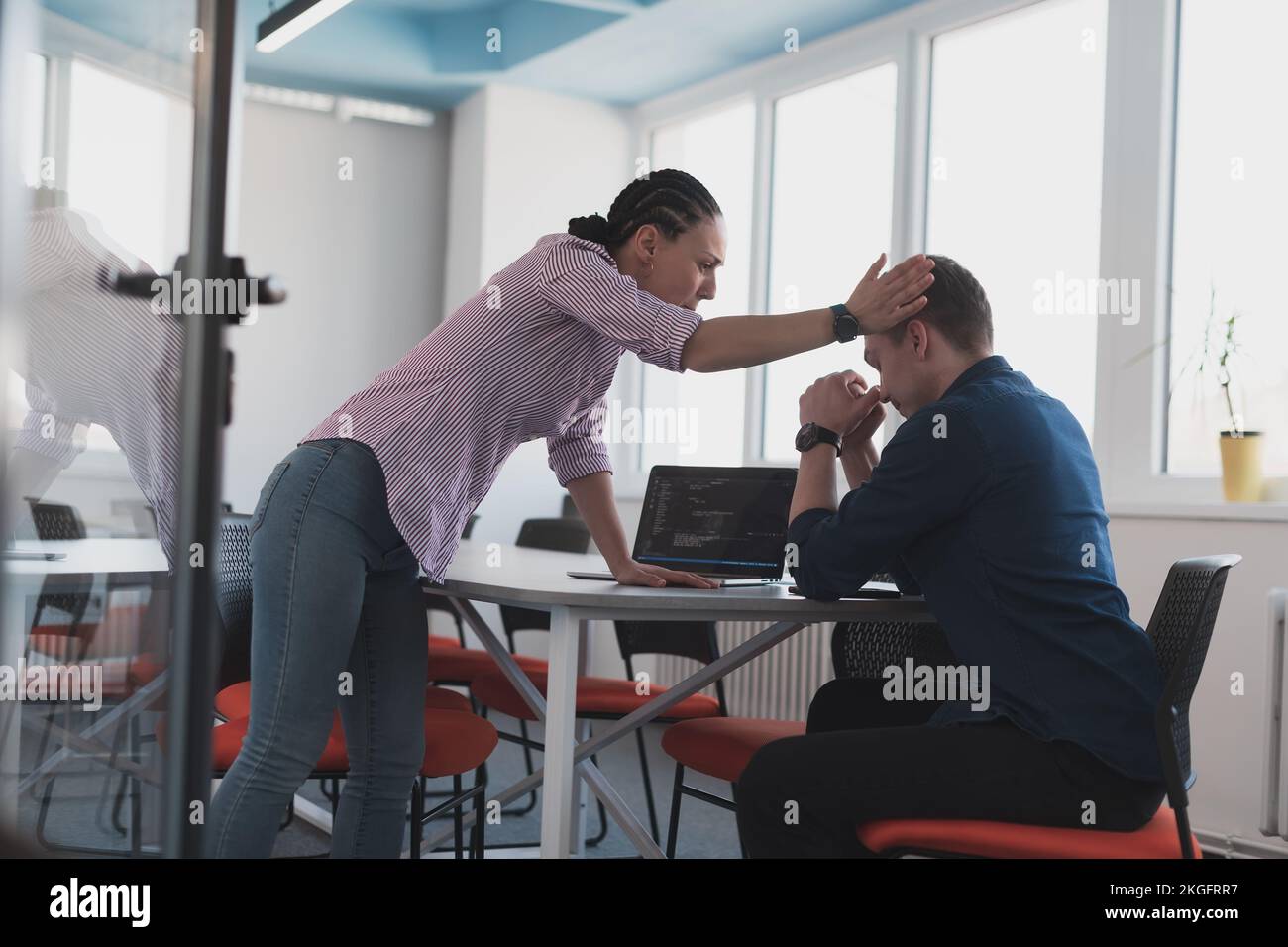 Emotional couple of young colleagues arguing in modern office. African ...