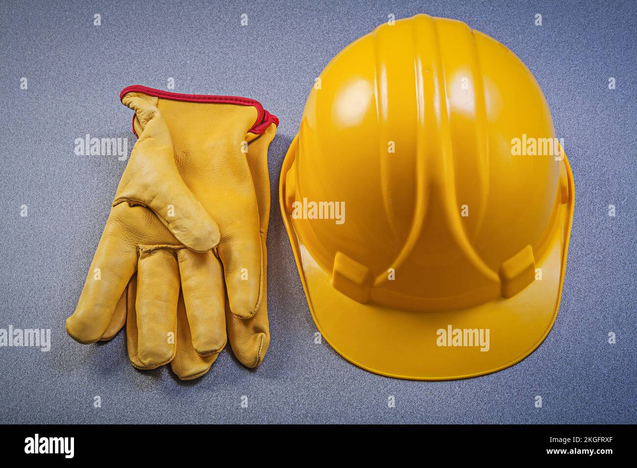 Yellow hard hat safety gloves on grey background construction concept ...
