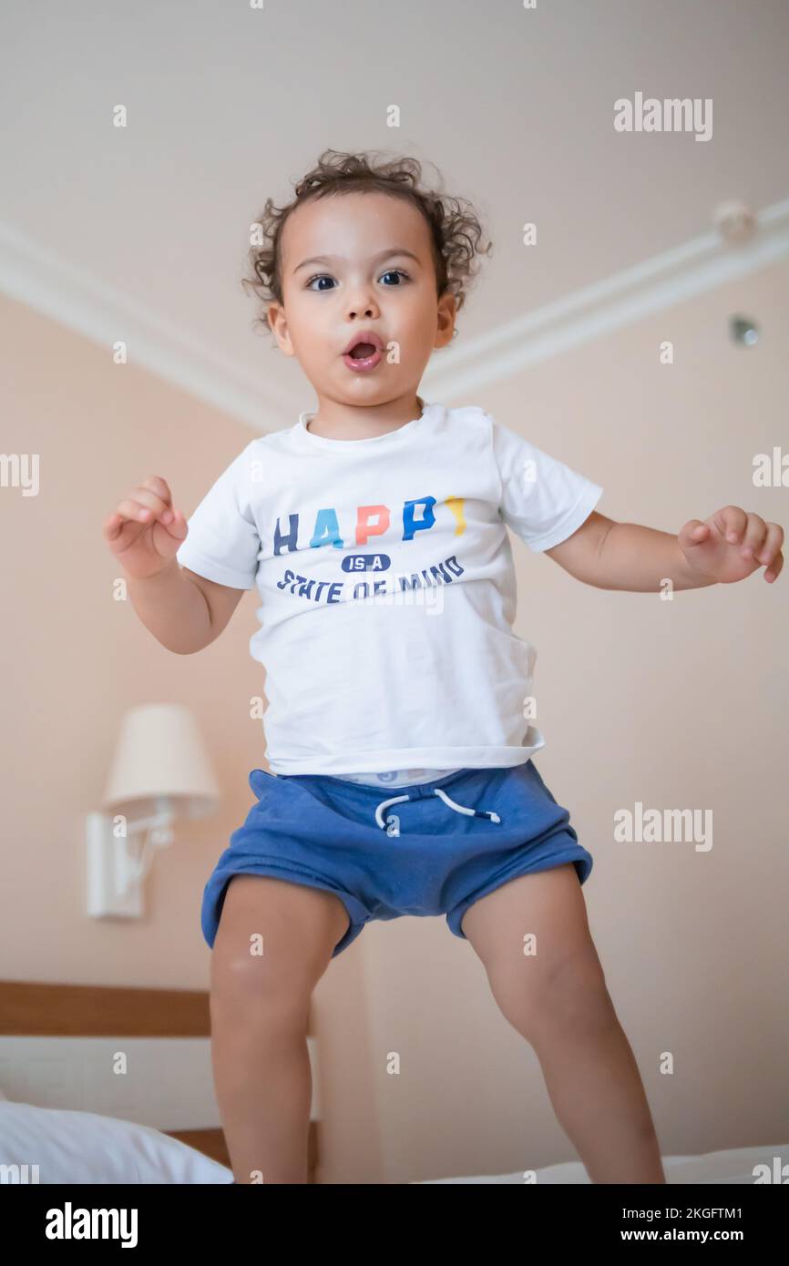 Funny happy kid jumping on parents bed in master bedroom Stock Photo ...