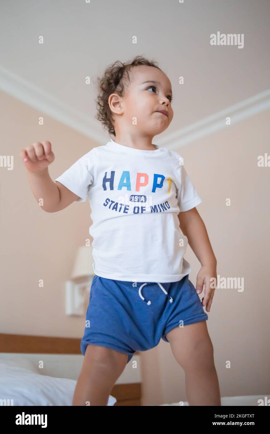 Funny happy kid jumping on parents bed in master bedroom Stock Photo ...
