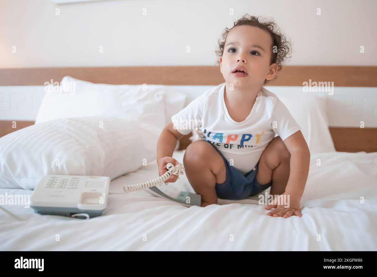 Happy kid calling on a push-button telephone in hotel room Stock Photo ...
