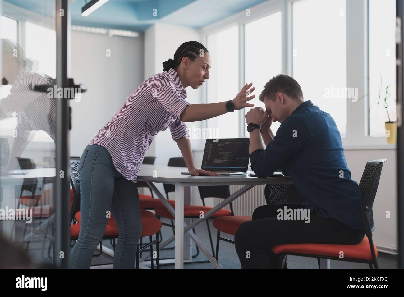 Emotional couple of young colleagues arguing in modern office. African ...