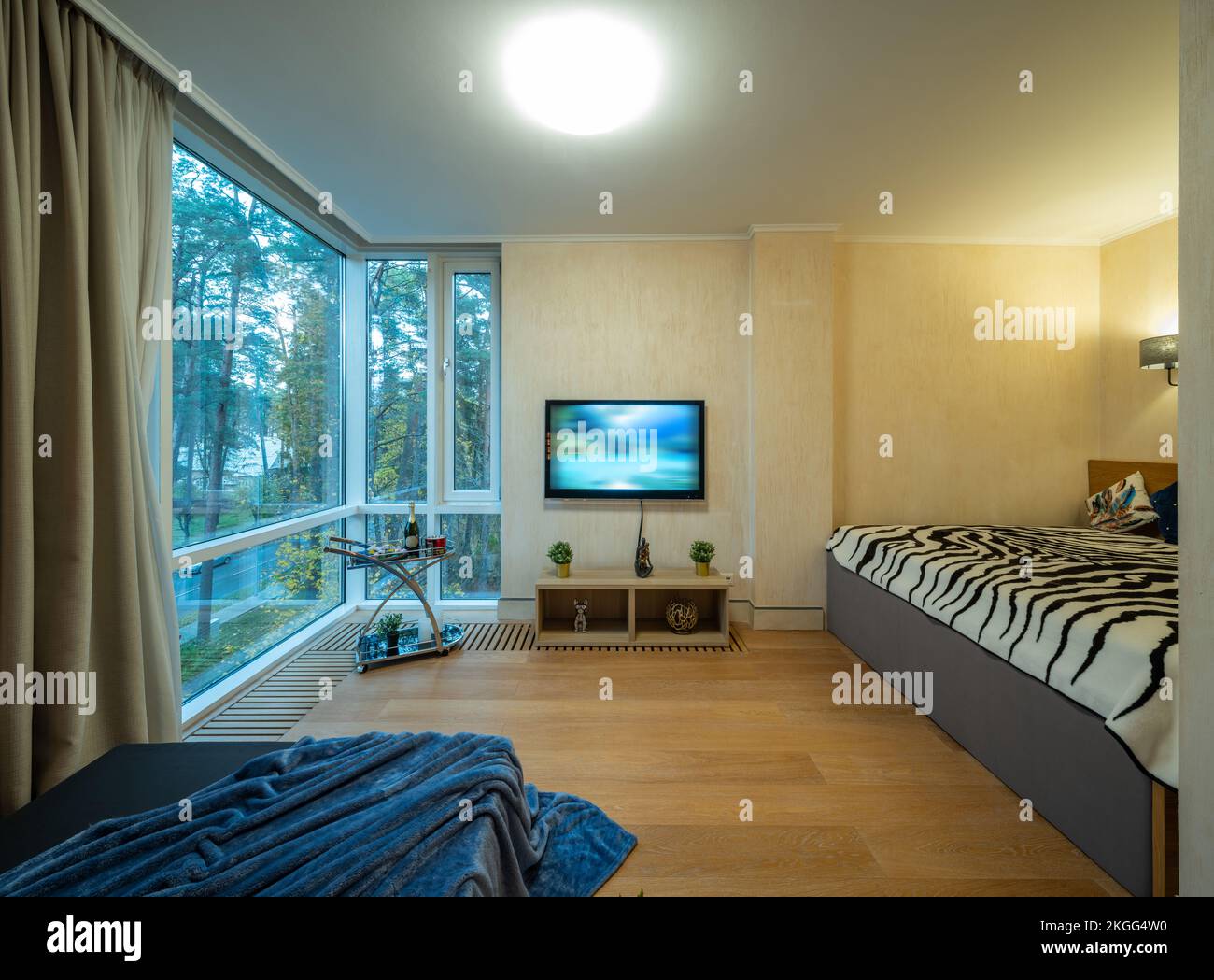 Modern interior of bedroom with lounge zone. TV on wall Stock Photo - Alamy