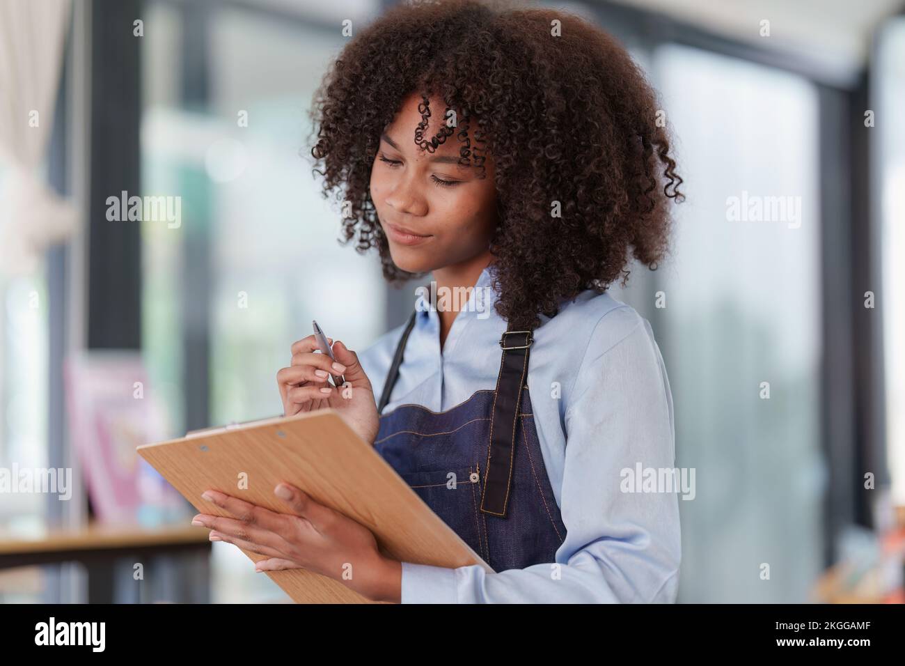 Young Female manager in restaurant with notebook. Woman coffee shop ...