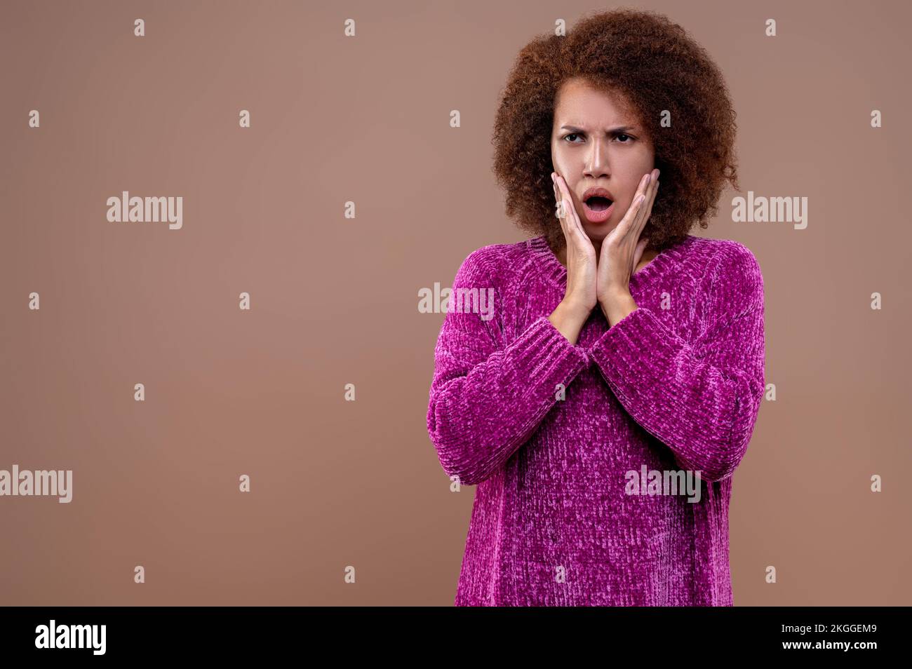 Dark-haired young woman looking chocked and stressed Stock Photo - Alamy