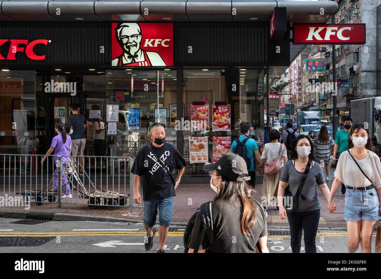 Pedestrians cross the street in front of the American fast food chicken ...