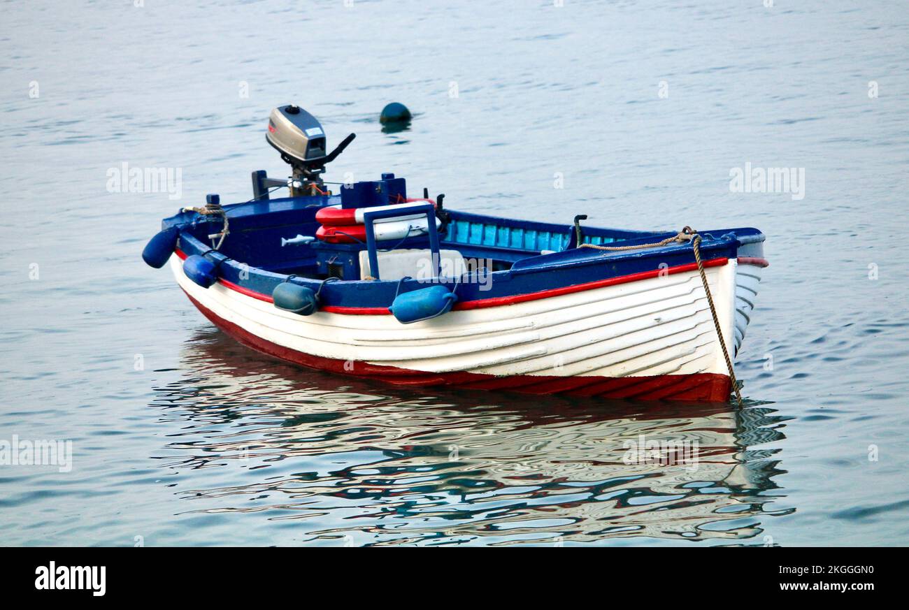 A small wooden fishing boat with a motor on the water Stock Photo - Alamy